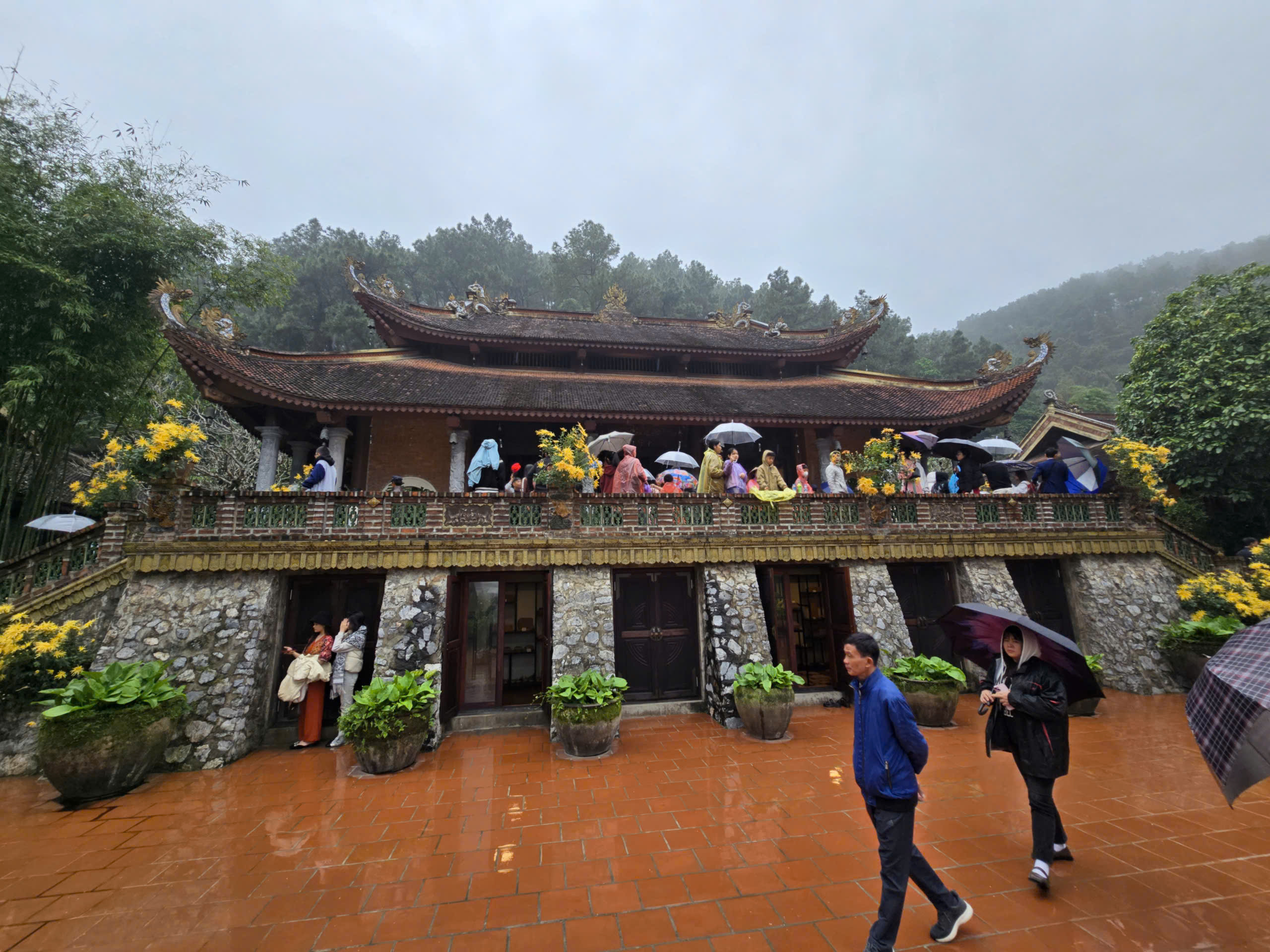 Visitors brave the spring rain to admire the scenery at Dia Tang Phi ...