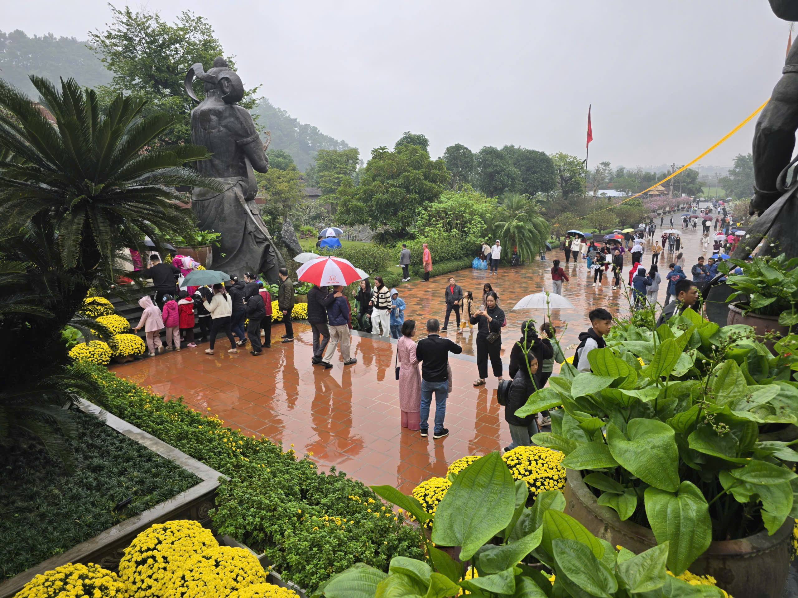Visitors brave the spring rain to admire the scenery at Dia Tang Phi ...